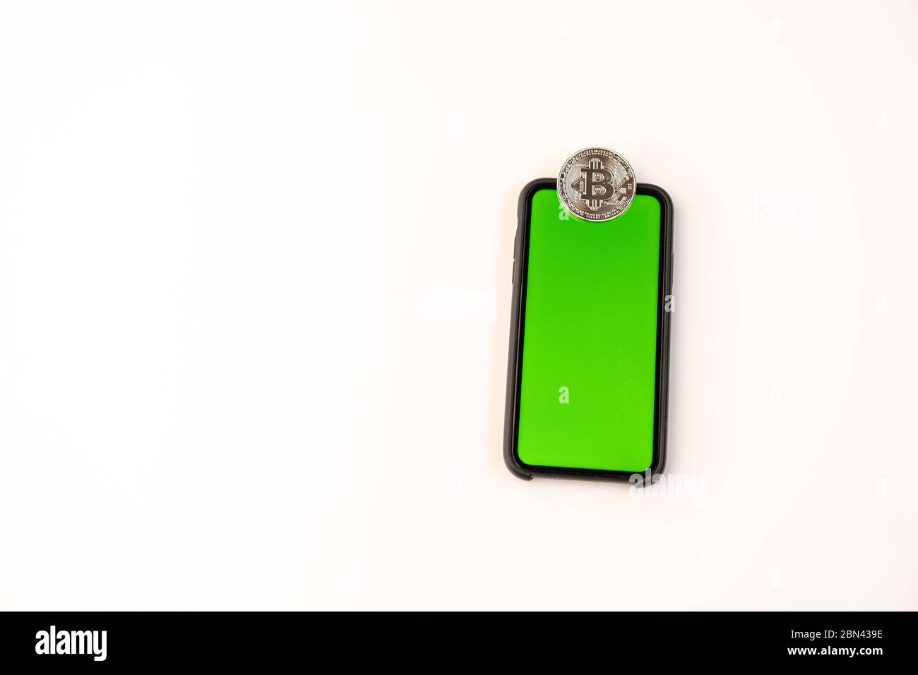 Gold Bitcoin on modern mobile phone with green screen isolated on white ...