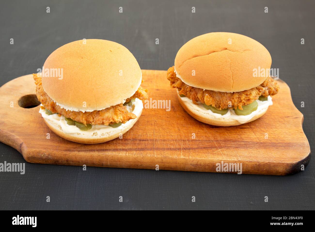 Homemade Burgers with fried chicken strips on a rustic wooden board on ...