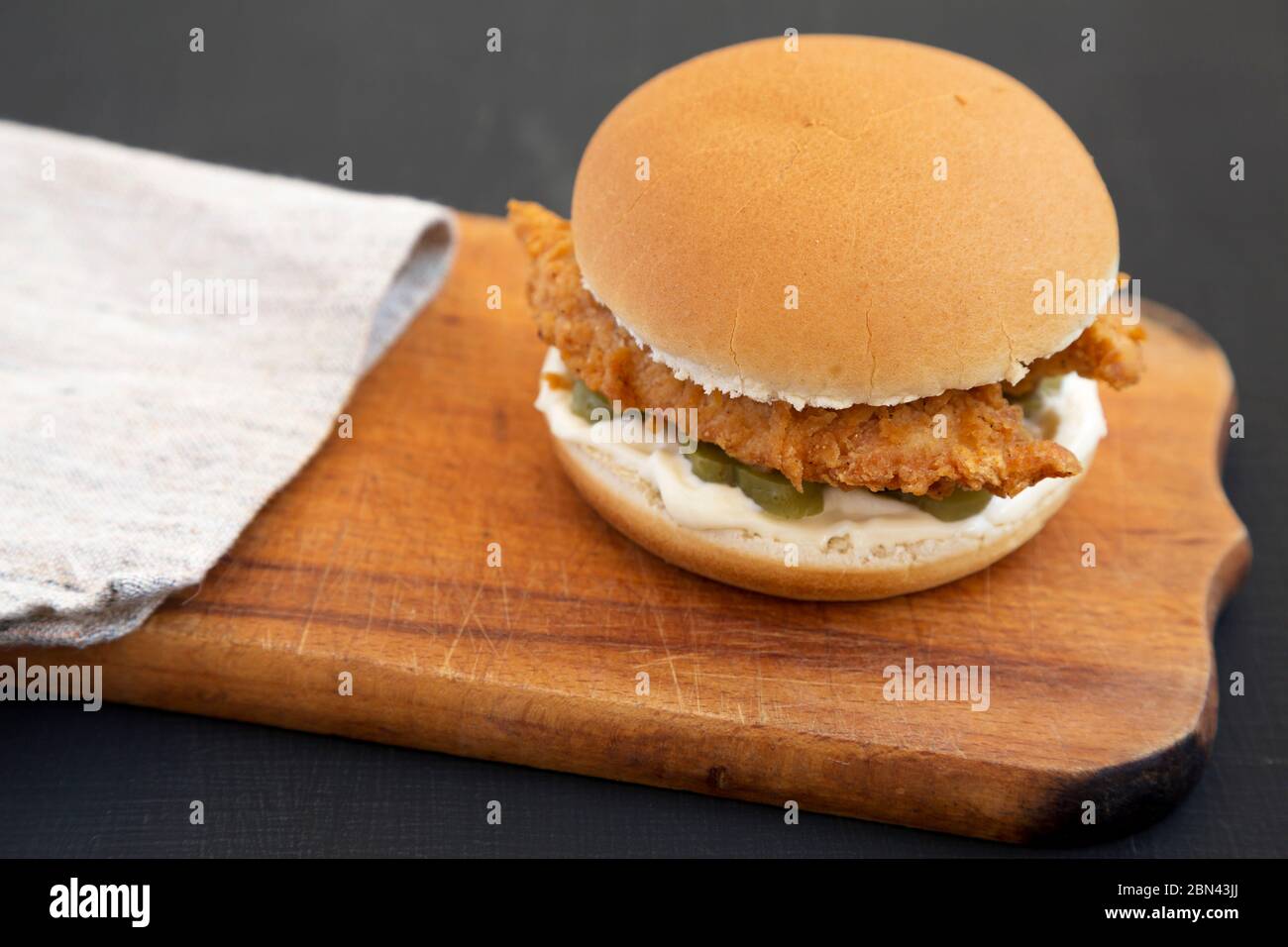 Homemade Burger with fried chicken strips on a rustic wooden board on a ...