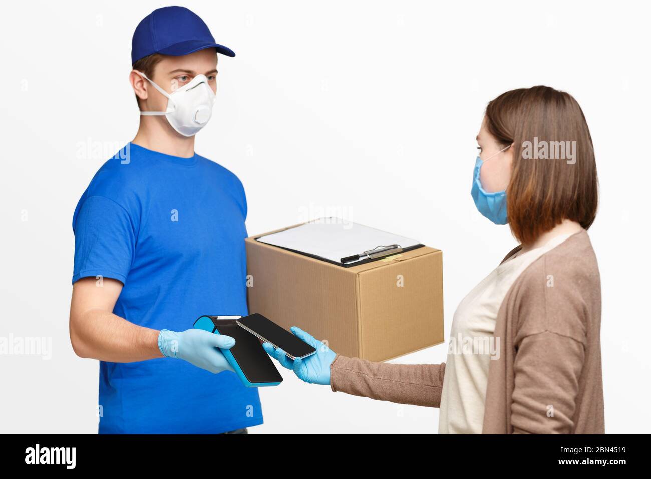 Girl receives parcel and pays using smartphone and terminal Stock Photo ...