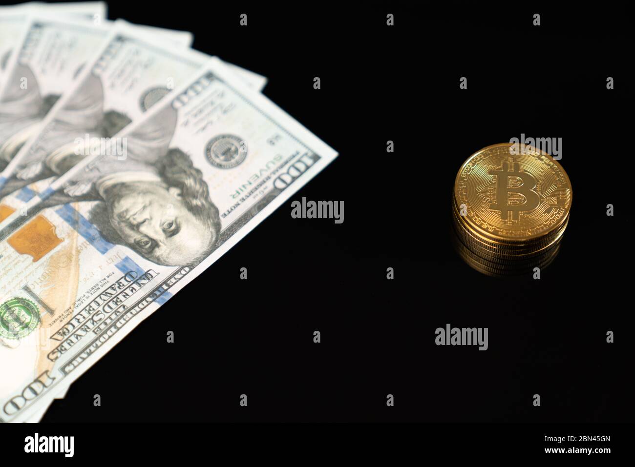 Bitcoin golden coin on the right side and dollar bills on the left side ...
