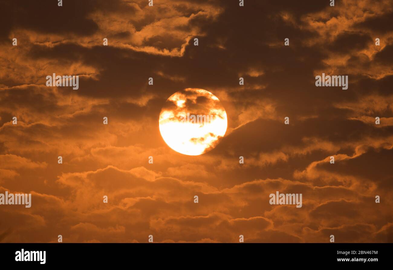 Sun behind clouds Stock Photo - Alamy