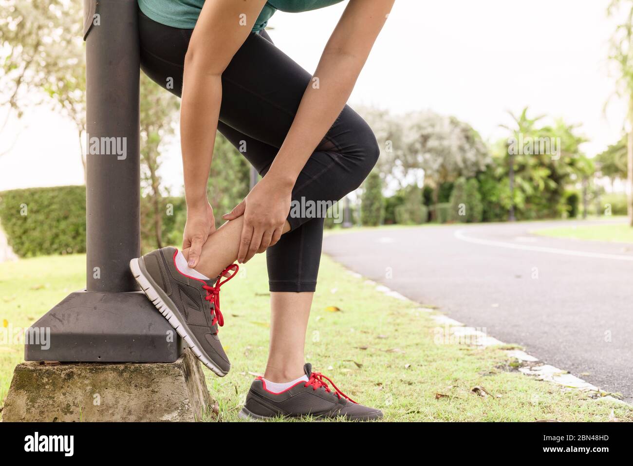 fitness woman runner feel pain on ankle leg. Outdoor exercise ...