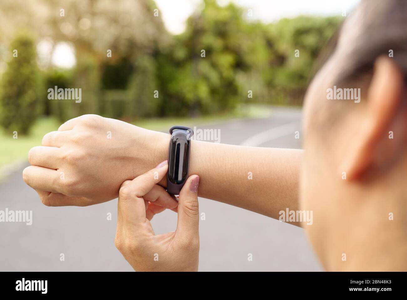 fitness woman runner setting up smart watch before running. Outdoor ...