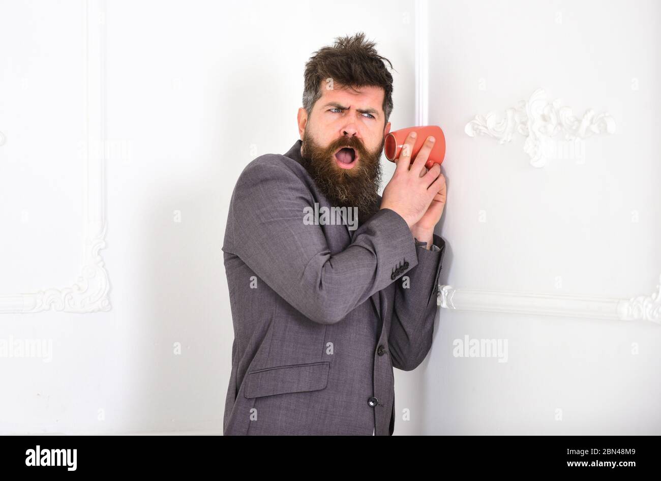 Hipster in classic suit on outraged face secretly listen conversation ...