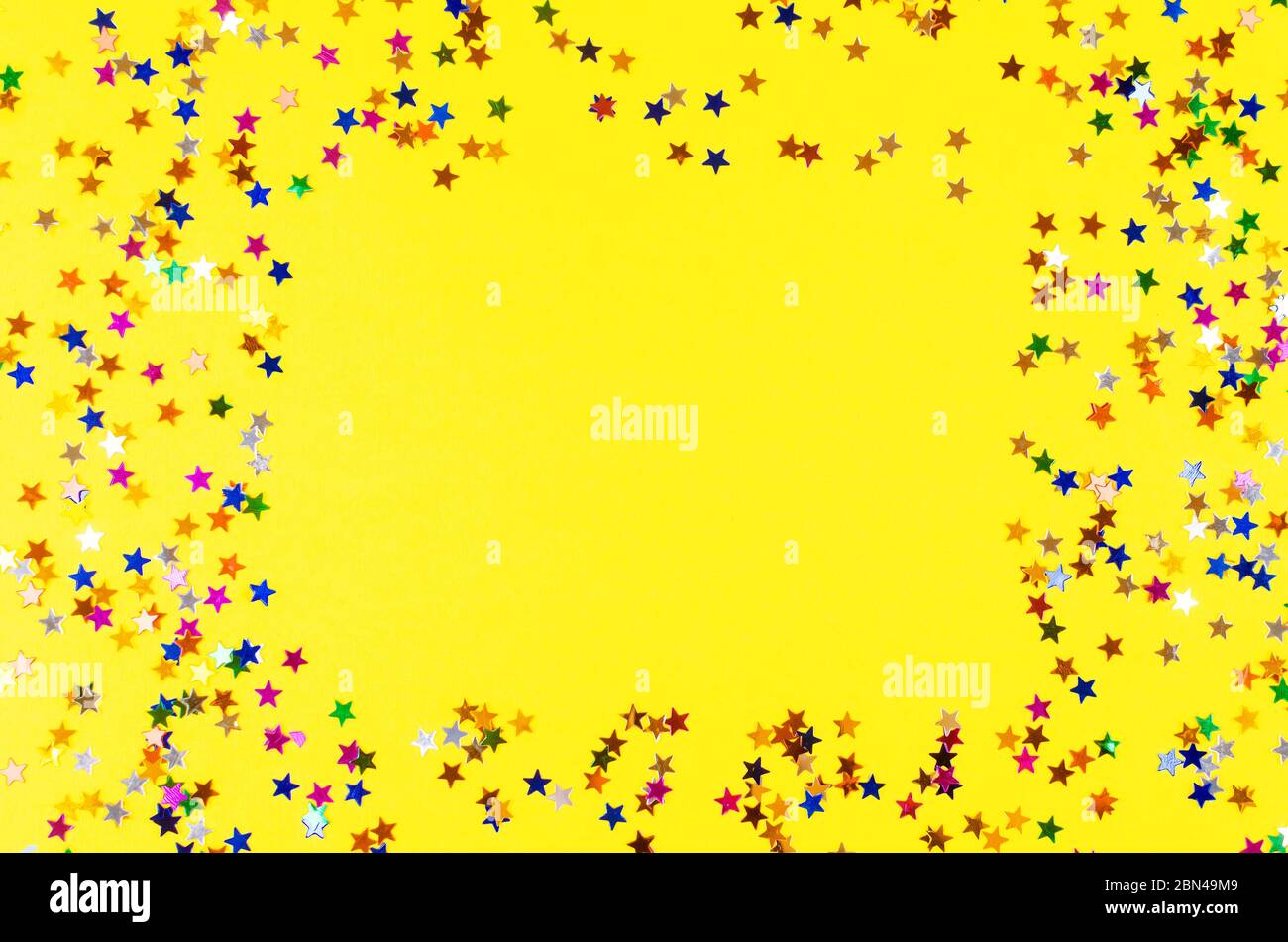 Frame from Shining colorful stars on yellow background. Top view, copy ...