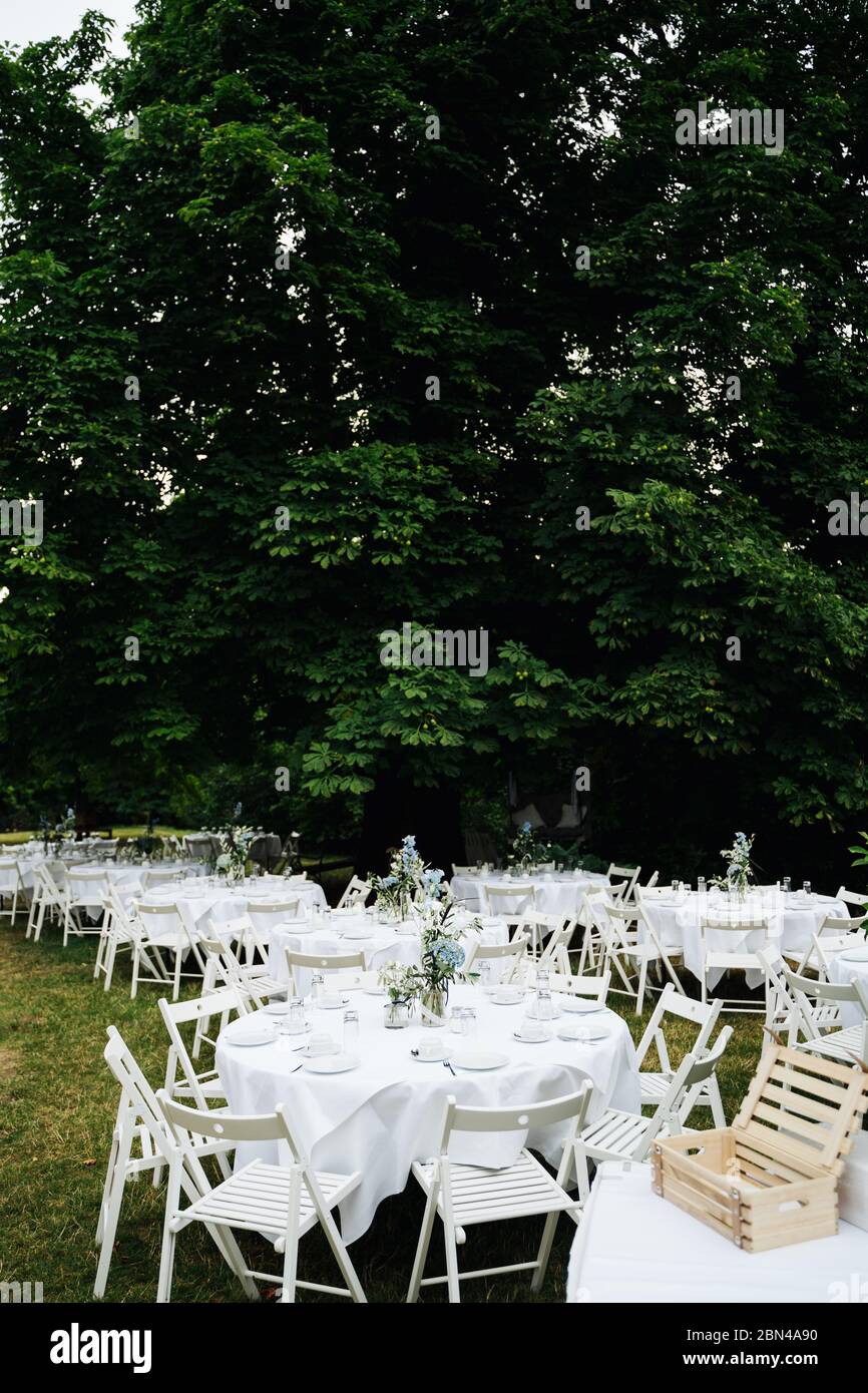 photo of an empty wedding dinner tables in the garden Stock Photo - Alamy