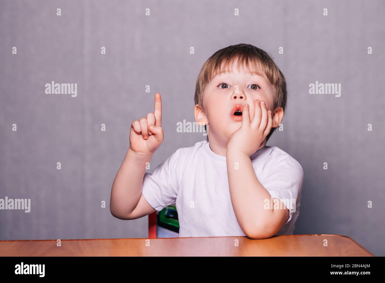 Little boy sitting on chair at the table Stock Photo - Alamy