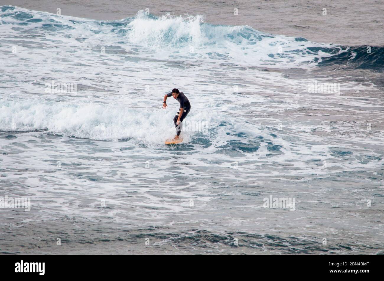 Okinawa / Japan - February 27, 2018: Surfer riding the waves of East ...
