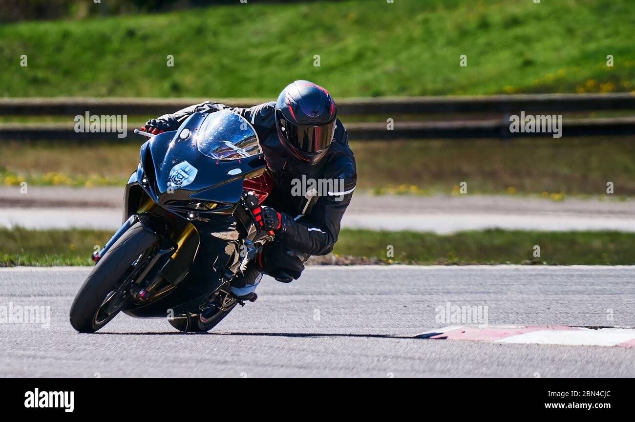 Motorcycle practice leaning into a fast corner on track Stock Photo - Alamy