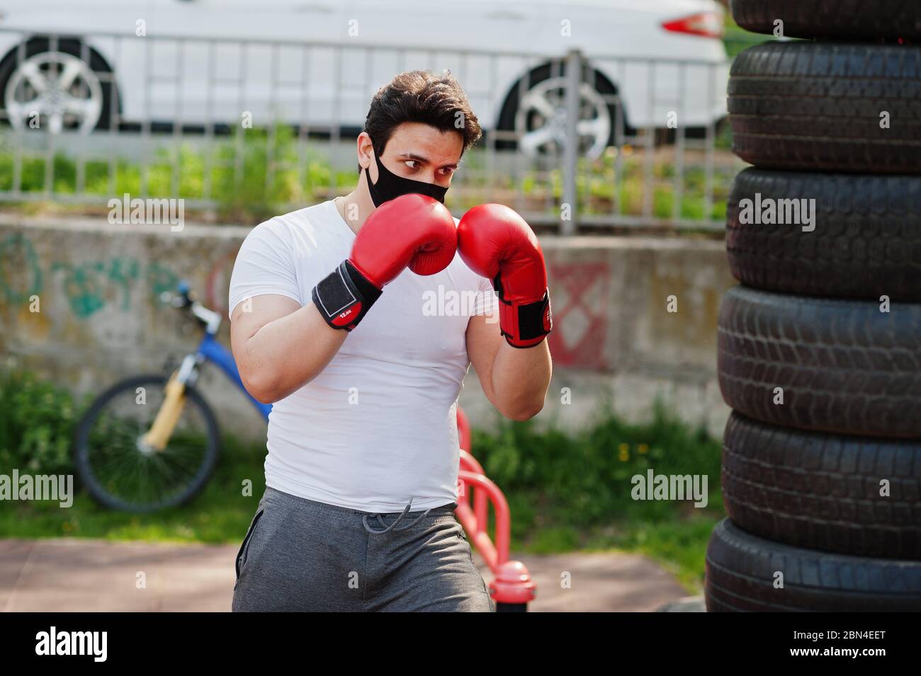 Portrait sports arabian boxer man in black medical face mask boxing ...