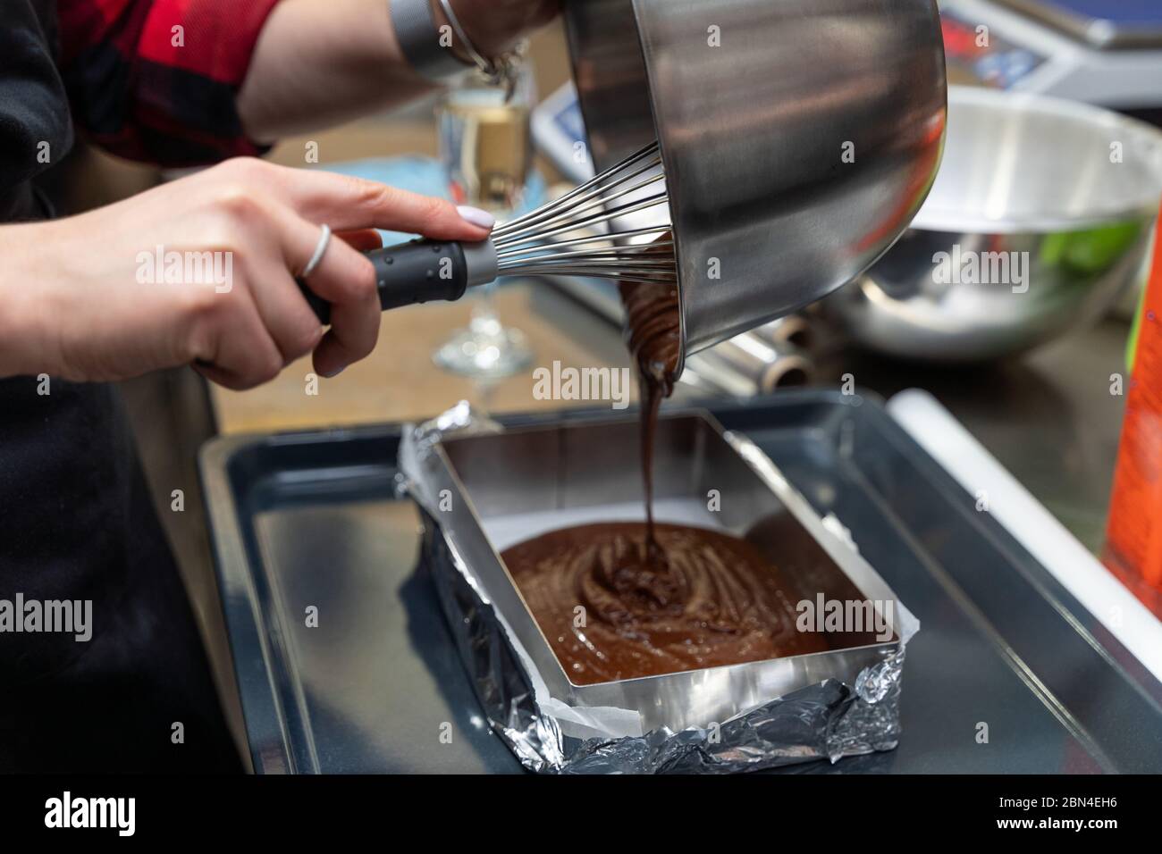Woman pouring chocolate batter into a pan Stock Photo - Alamy