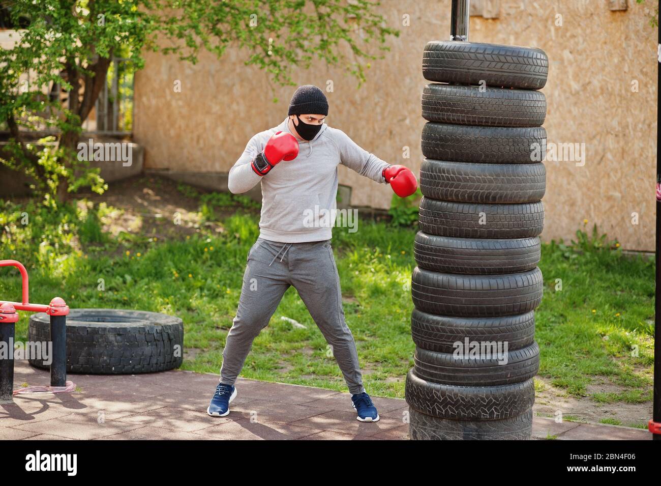 Portrait sports arabian boxer man in black medical face mask boxing ...