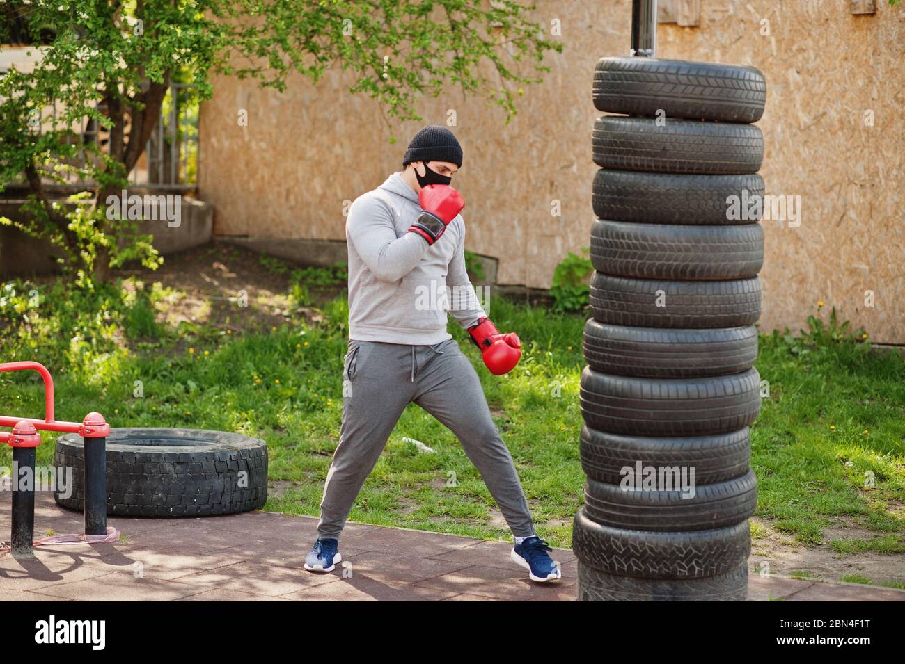 Portrait sports arabian boxer man in black medical face mask boxing ...