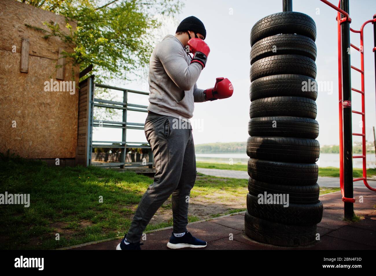 Portrait sports arabian boxer man in black medical face mask boxing ...