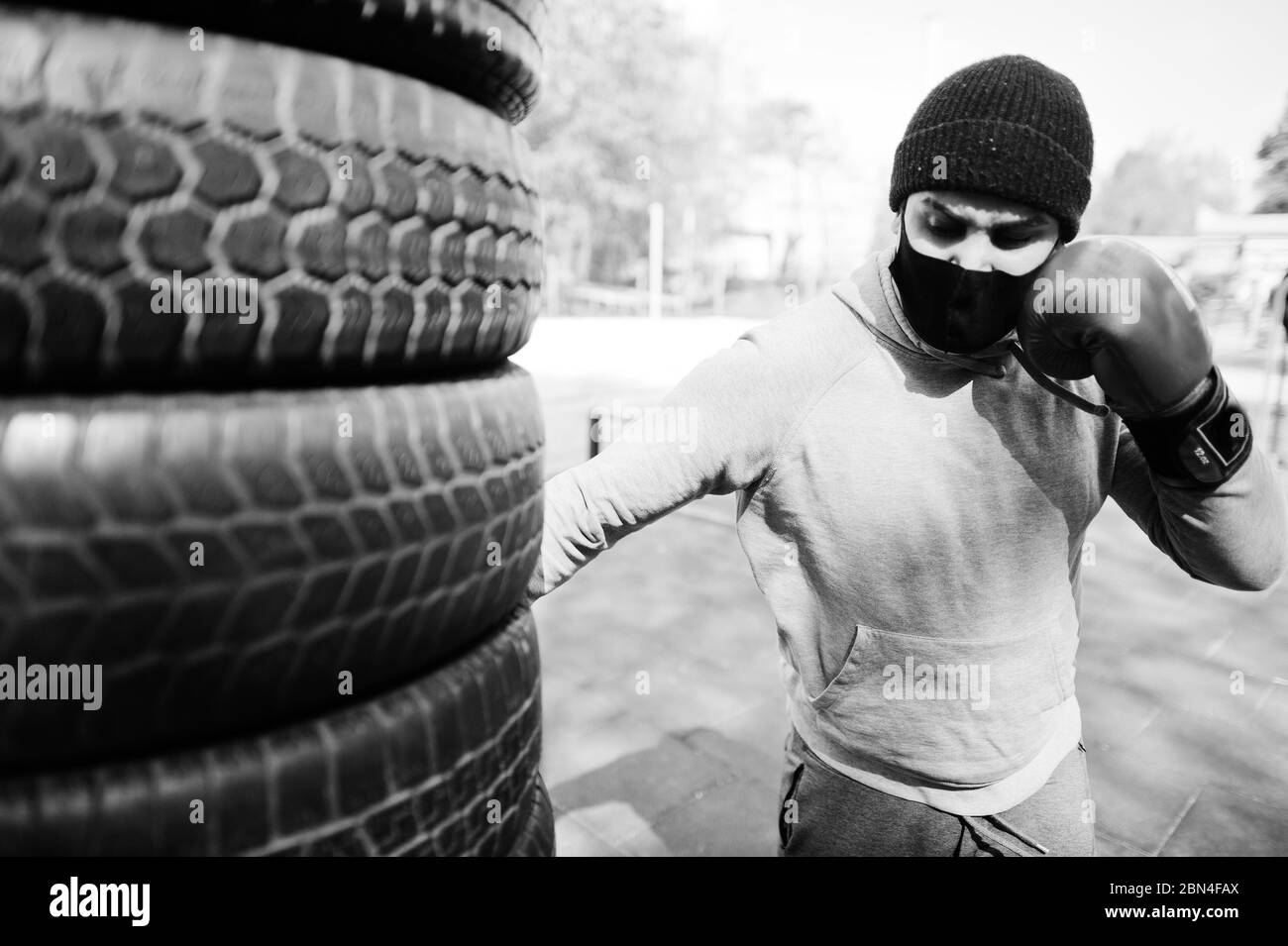Portrait sports arabian boxer man in black medical face mask boxing ...