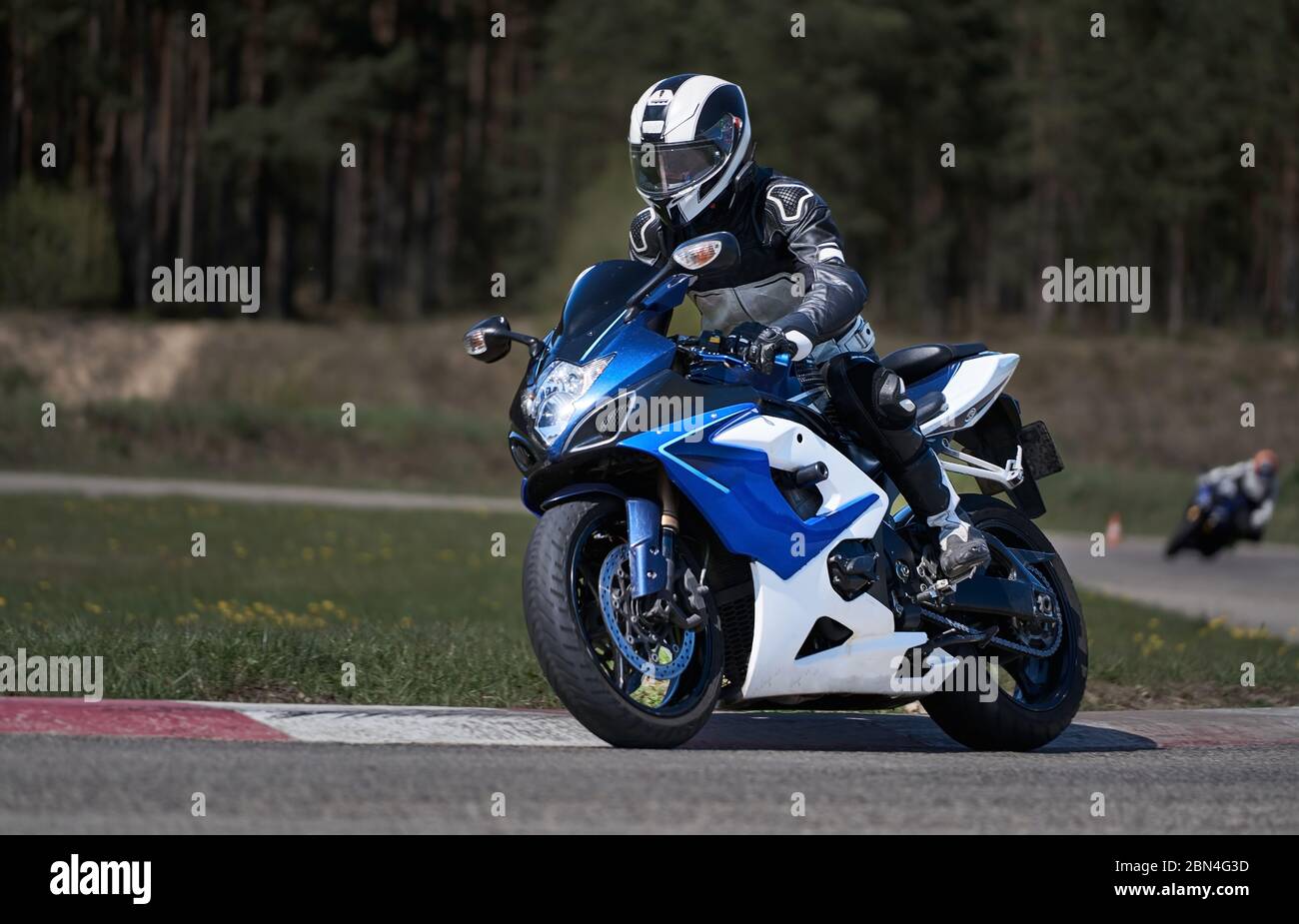 Motorcycle practice leaning into a fast corner on track Stock Photo - Alamy