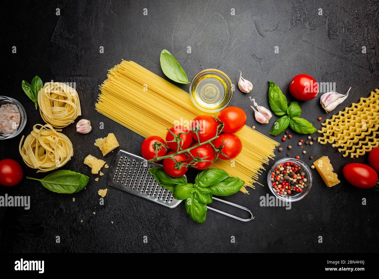 Pasta background. Several types of dry pasta with vegetables and herbs ...