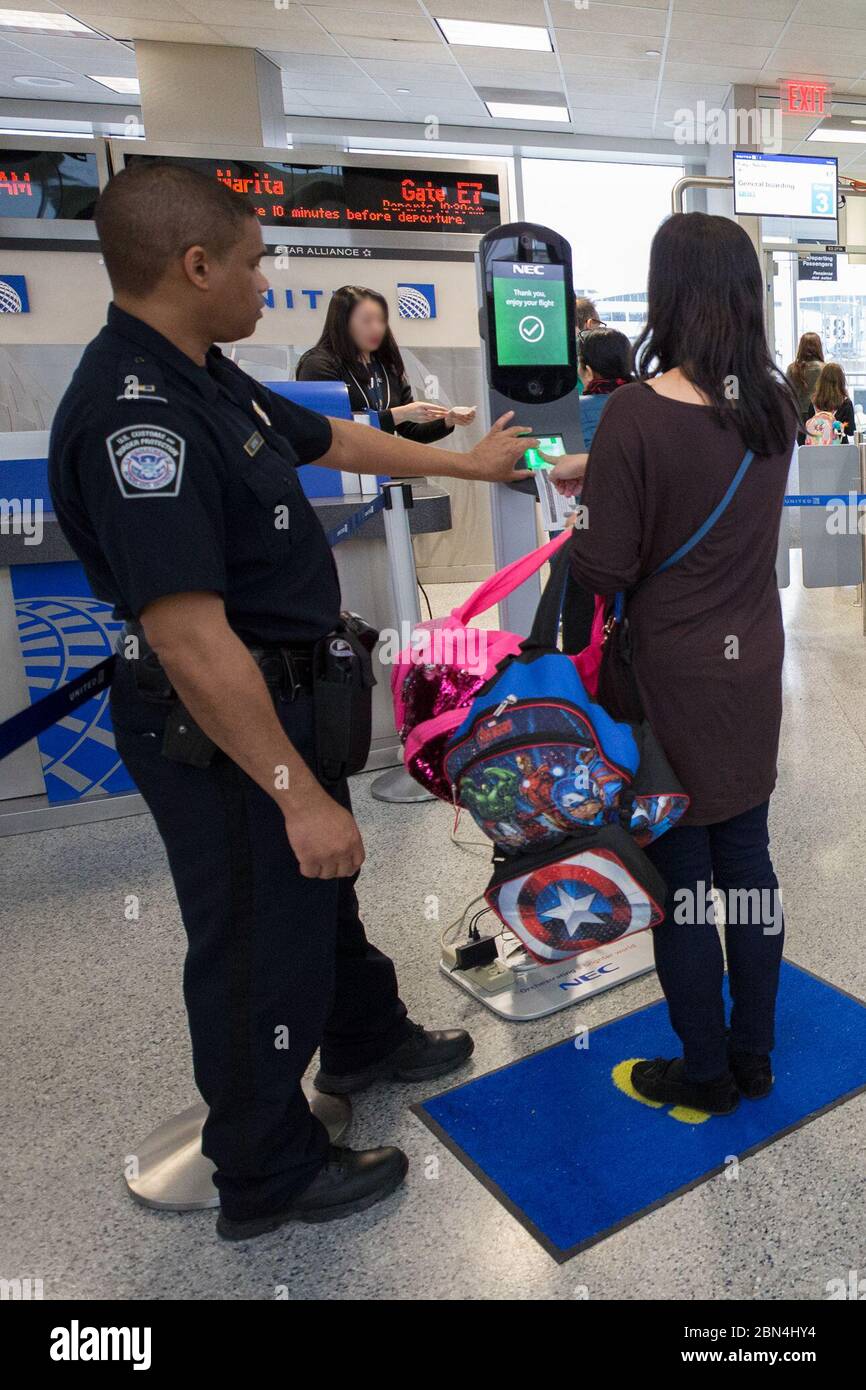 A U.S. Customs and Border Protection officer assists a passenger with ...