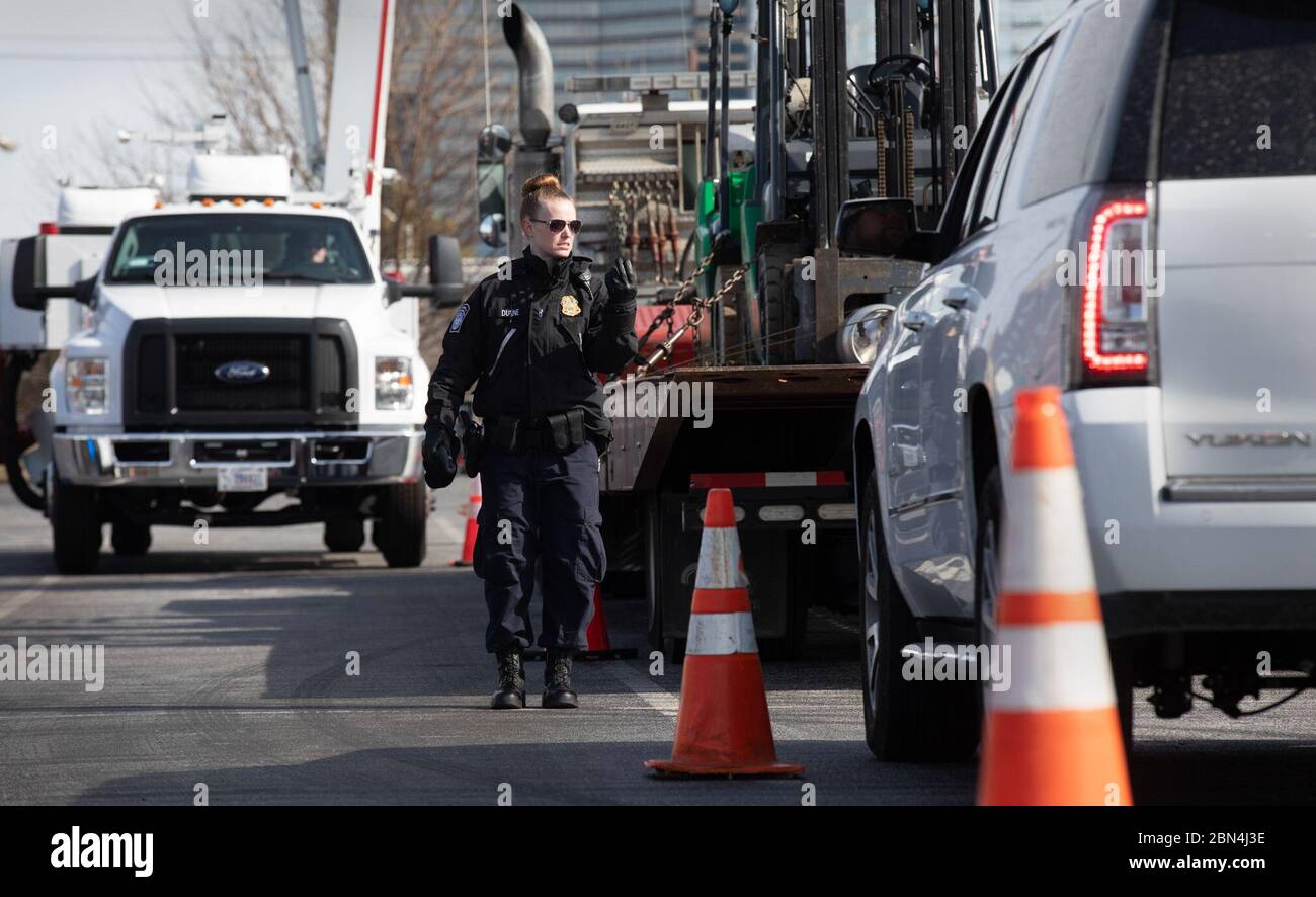 A U.S. Customs and Border Protection officer directs vehicles during ...