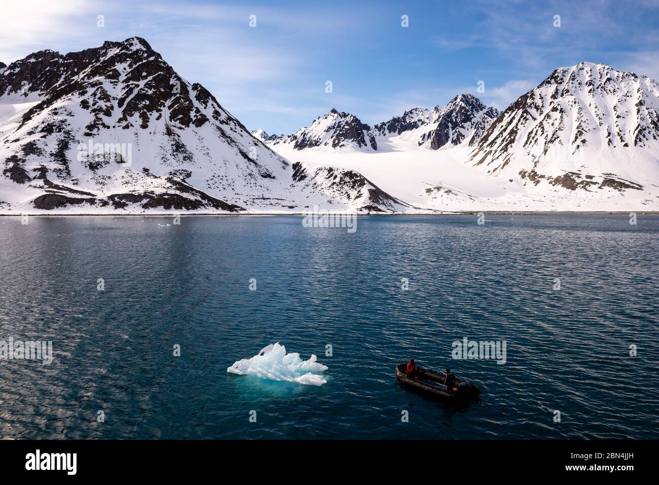 Inflatable boat with one person in Arctic waters, Svalbard. Pushing ice ...