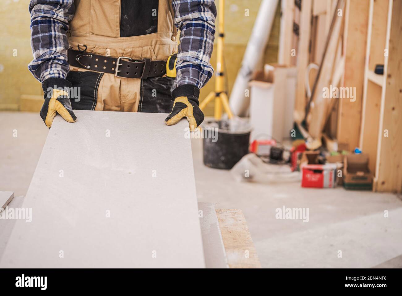Male Construction Worker Holding Long Piece Of Gray Drywall Material ...