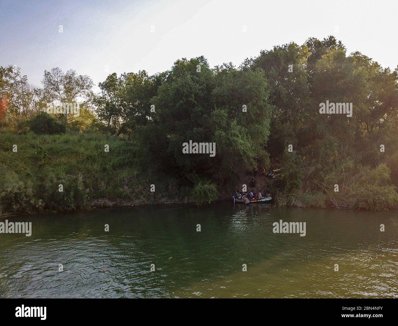 A group of 11 migrants, accompanied by two smugglers, crosses the Rio ...