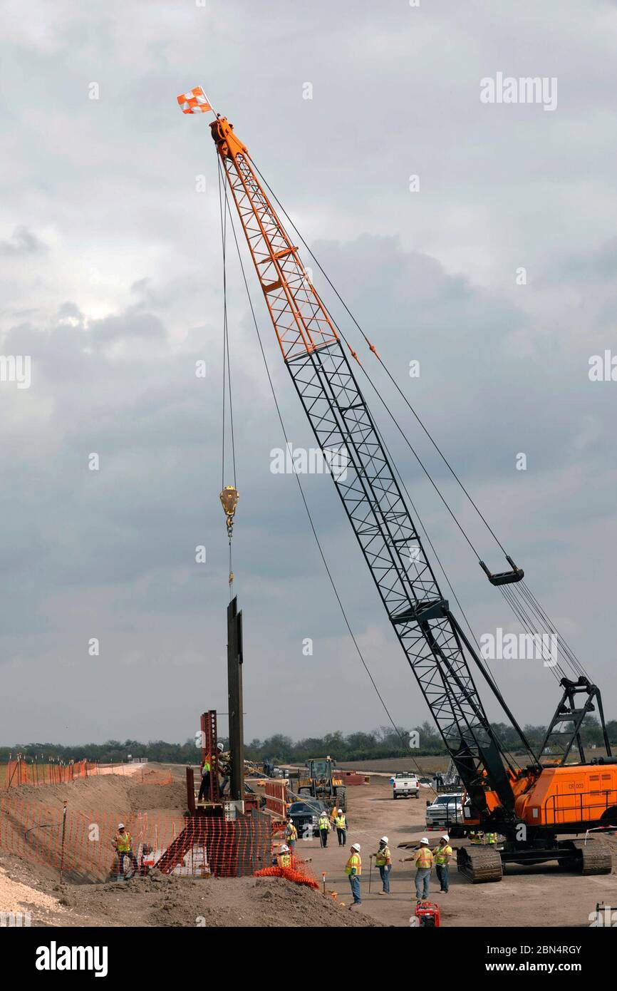 Construction workers install border wall panels in the Rio Grande ...