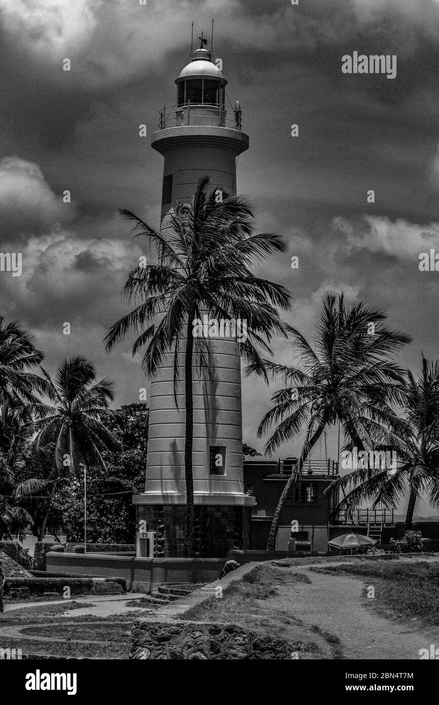 Black and white image of a cylindrical lighthouse with lantern amongst ...