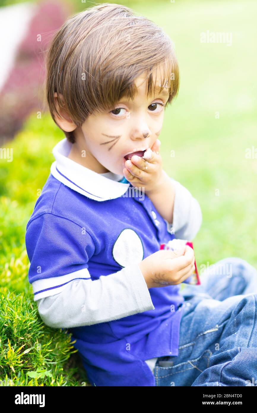 Happy Child Eating Delicious Food Outdoors Stock Photo - Alamy