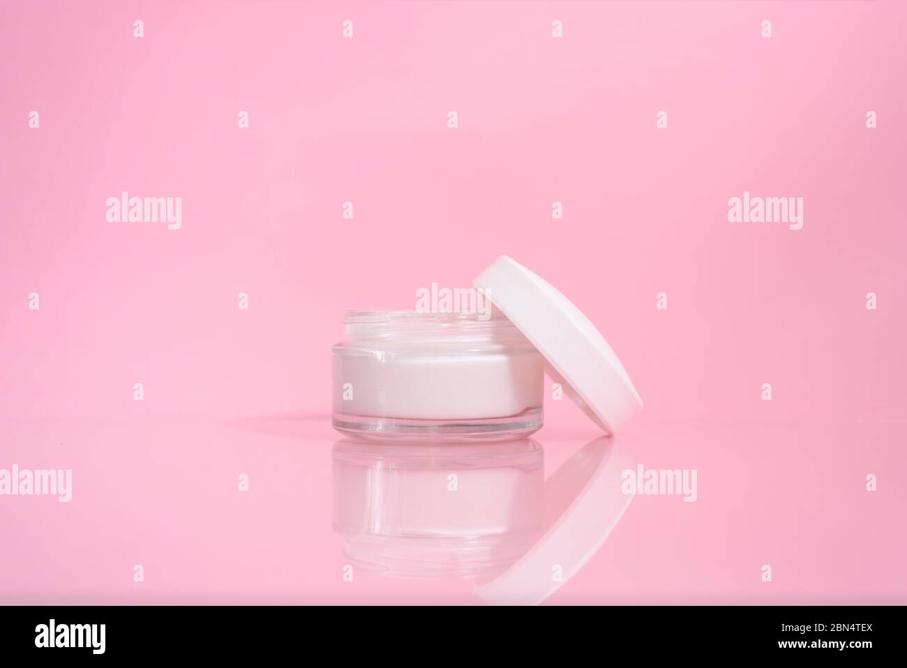 Opened jar of facial or body cream on the pink background. Nature skin ...