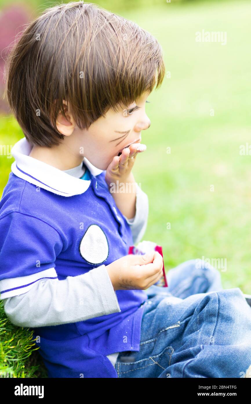 Happy Child Eating Delicious Food Outdoors Stock Photo - Alamy