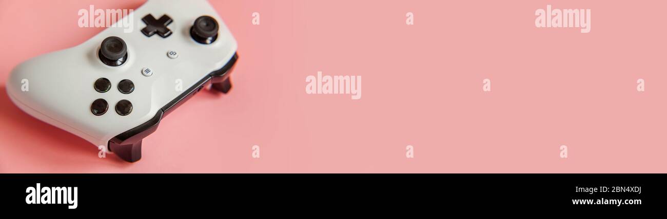 White joystick gamepad, game console isolated on pastel pink colourful ...