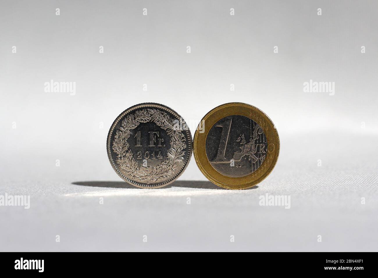 Swiss and Euro coin standing on a white background, close-up Stock ...