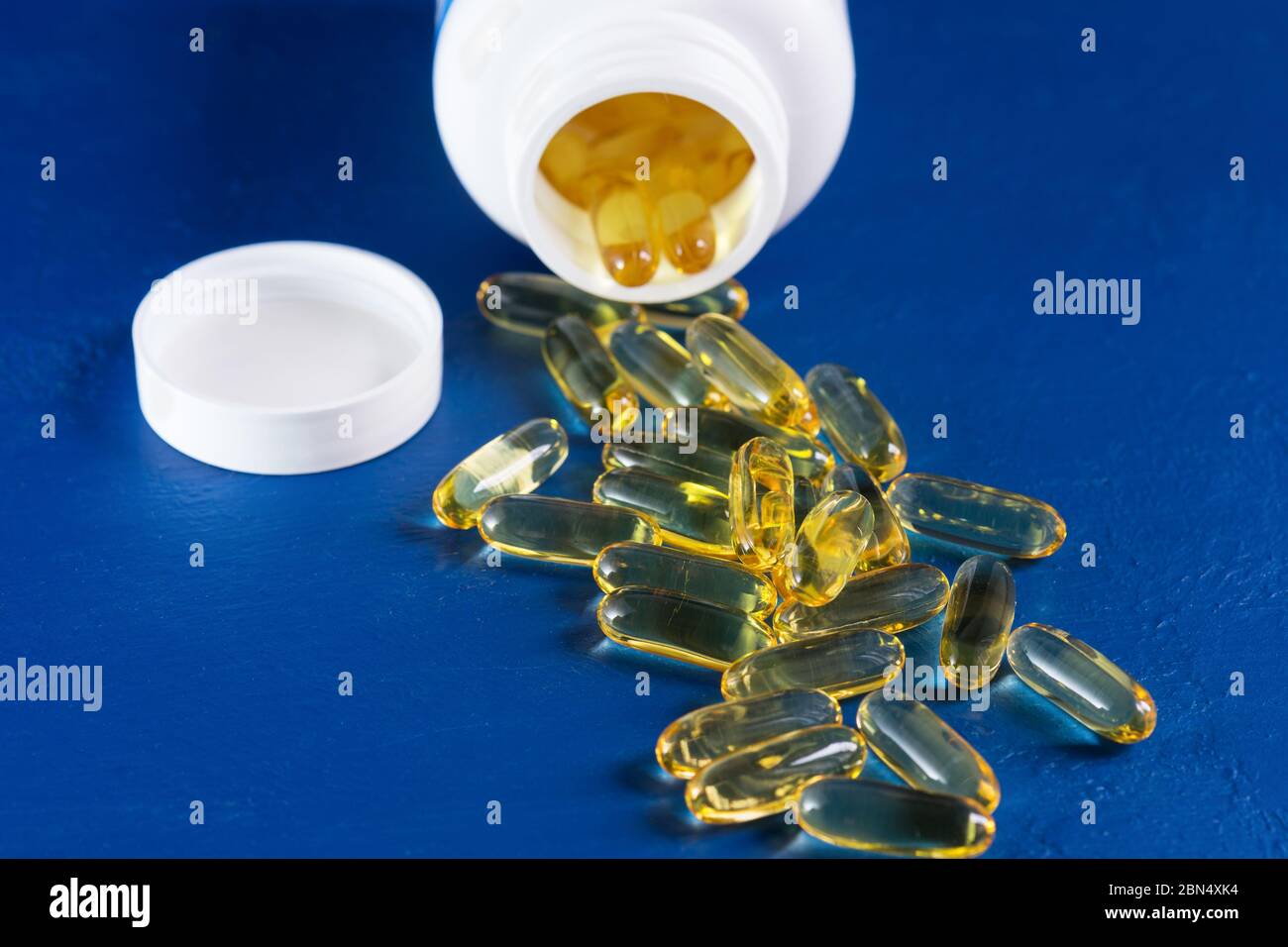 Many capsules Omega 3 on blue background. Close up, high resolution ...