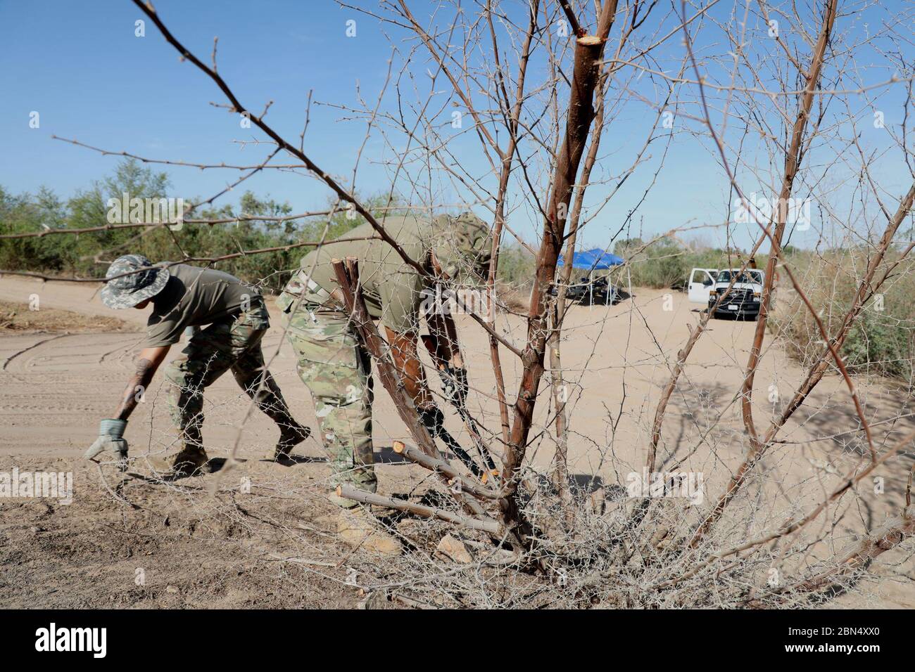 An Operation Guardian Support crew clears vegetation along the U.S ...