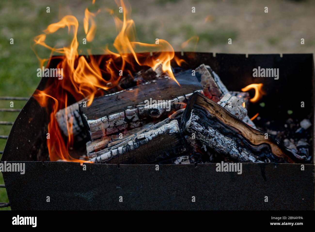 Burning firewood in barbeque grill. Cozy spring or summer evenings by ...