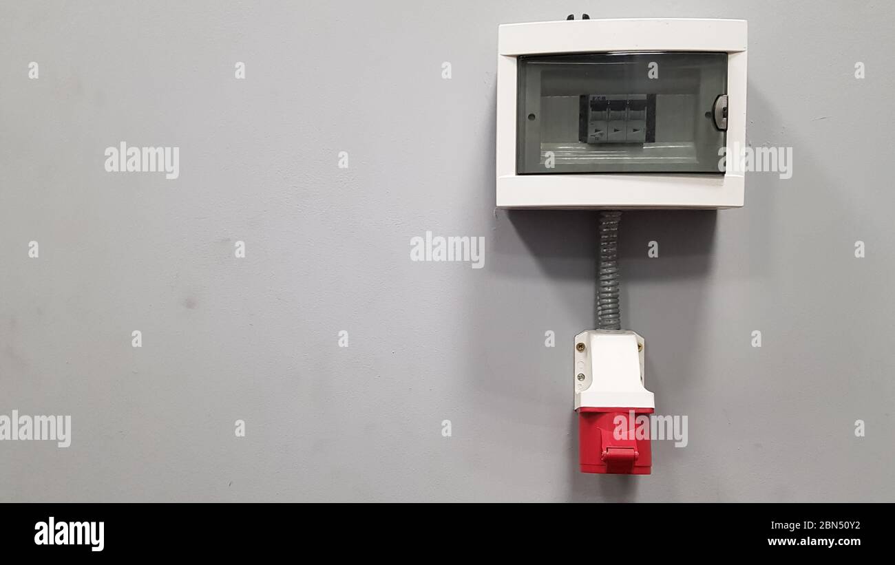 Three-phase 380 V high-voltage plug on a gray wall in a room with copy ...