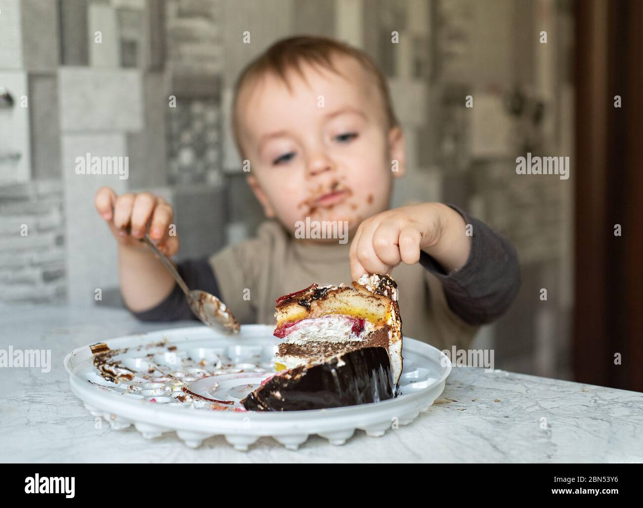 The child eats a cake and shows emotions. The child got dirty in a ...