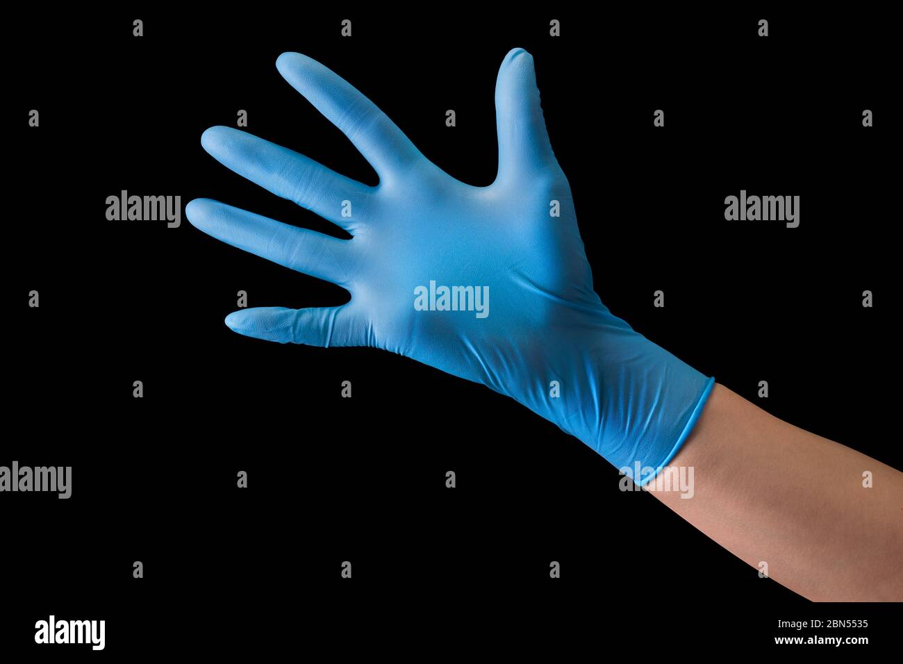Doctor's hand in sterile medical gloves showing palm isolated on black ...