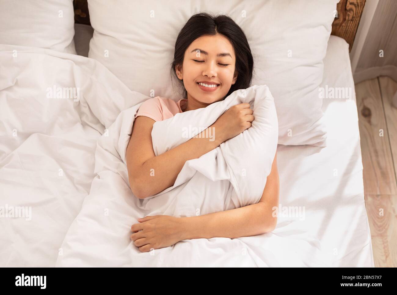 Rested Asian Woman Waking Up In Bed At Home, Top-View Stock Photo - Alamy