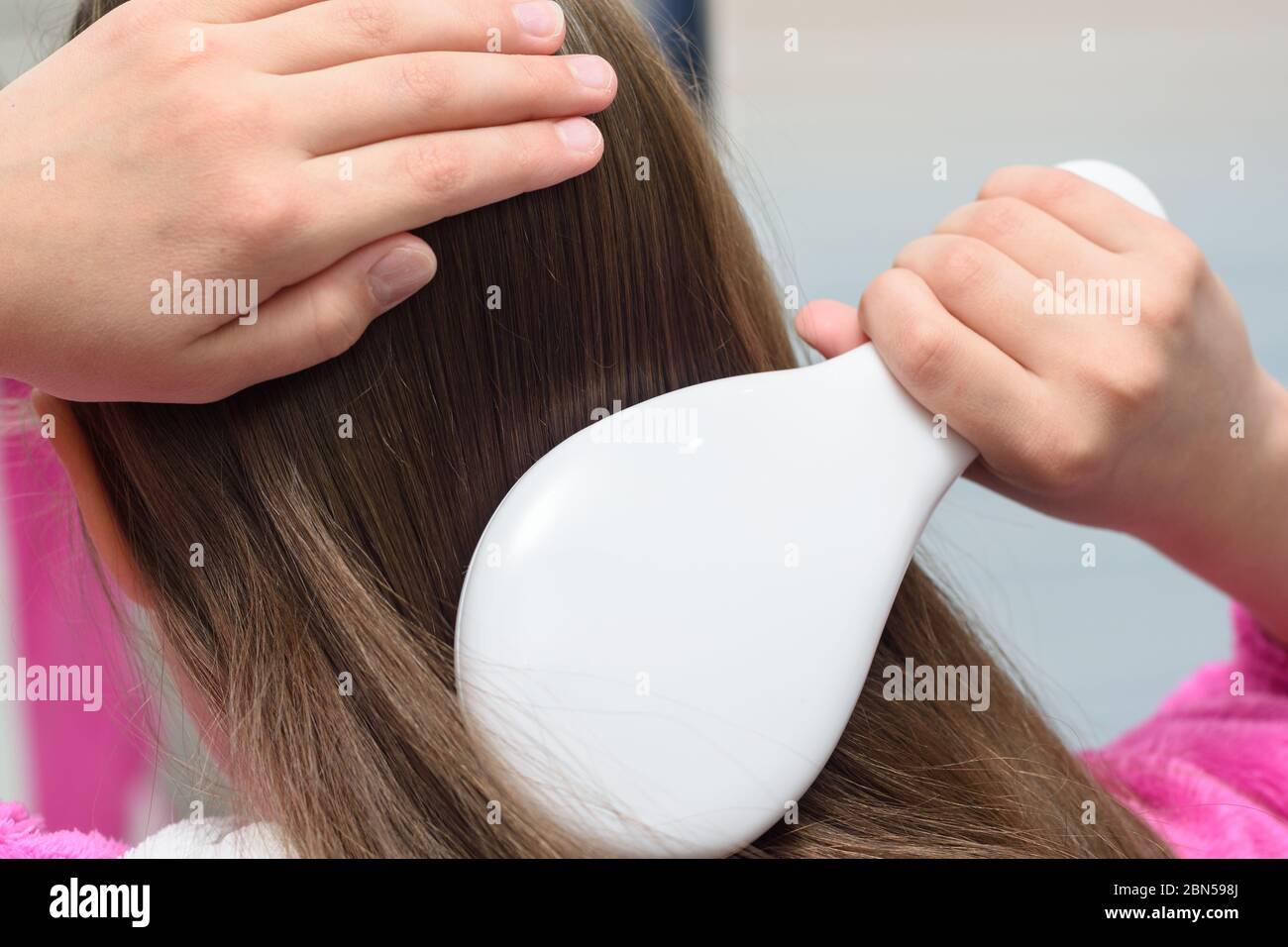 Teenager's hand combing long hair, close up Stock Photo - Alamy
