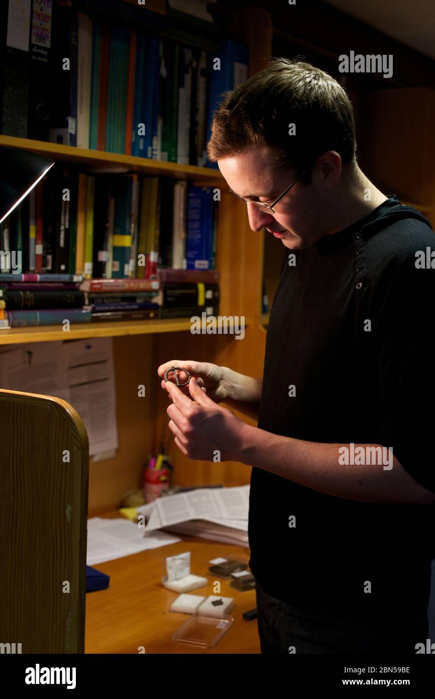Archaeology student analysing artefacts at a desk Stock Photo - Alamy