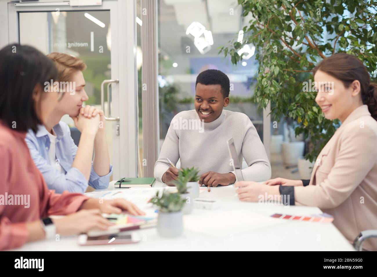 Multi-ethnic group of young business people collaborating on work ...
