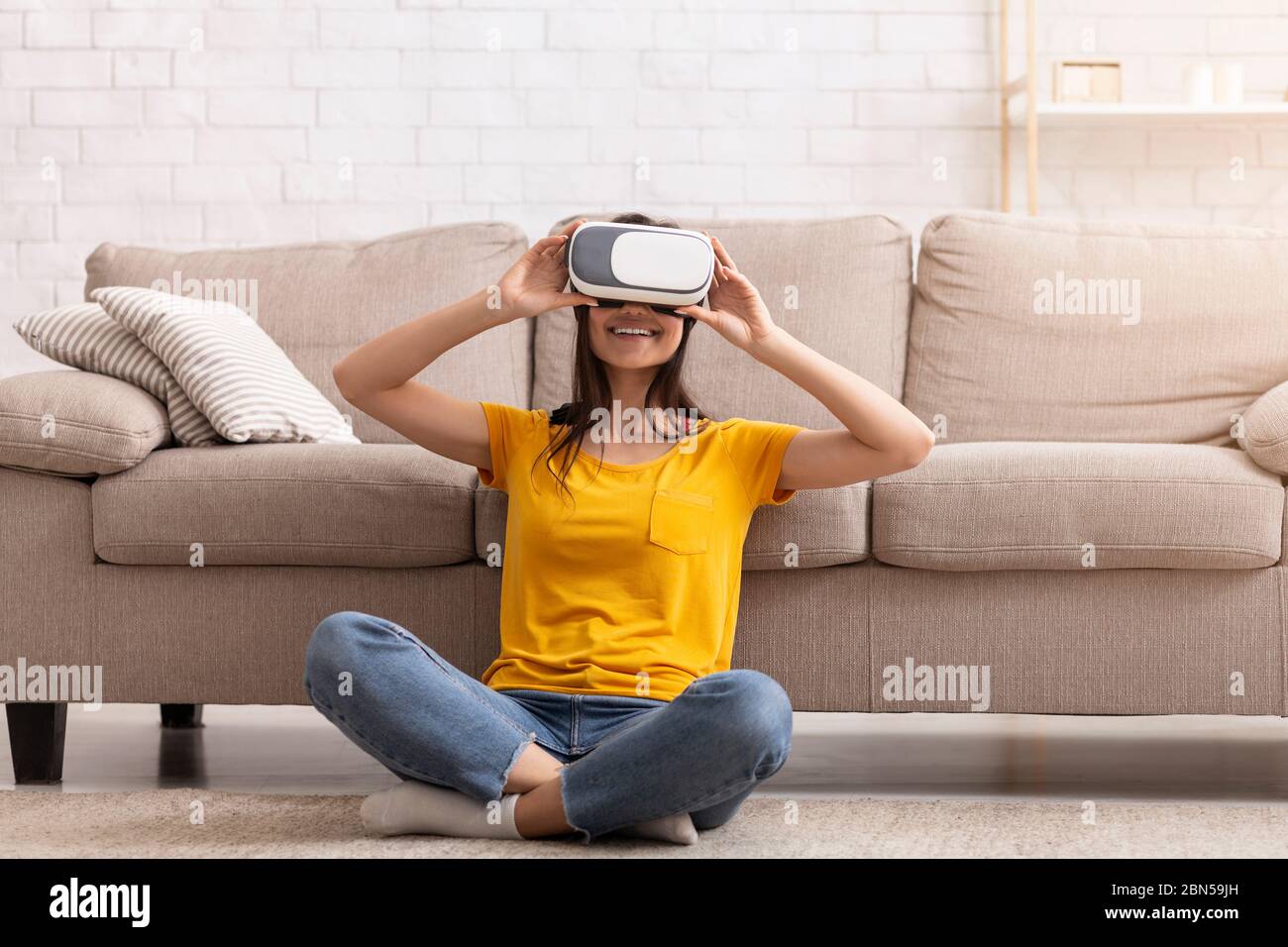 Millennial girl in virtual reality headset exploring cyberspace ...