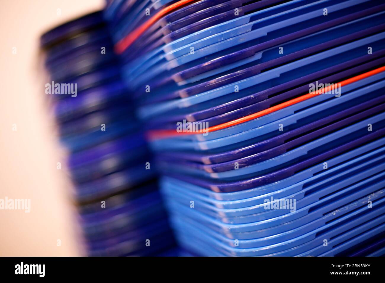 Stack of plastic blue and red trays in a canteen ready for use Stock ...
