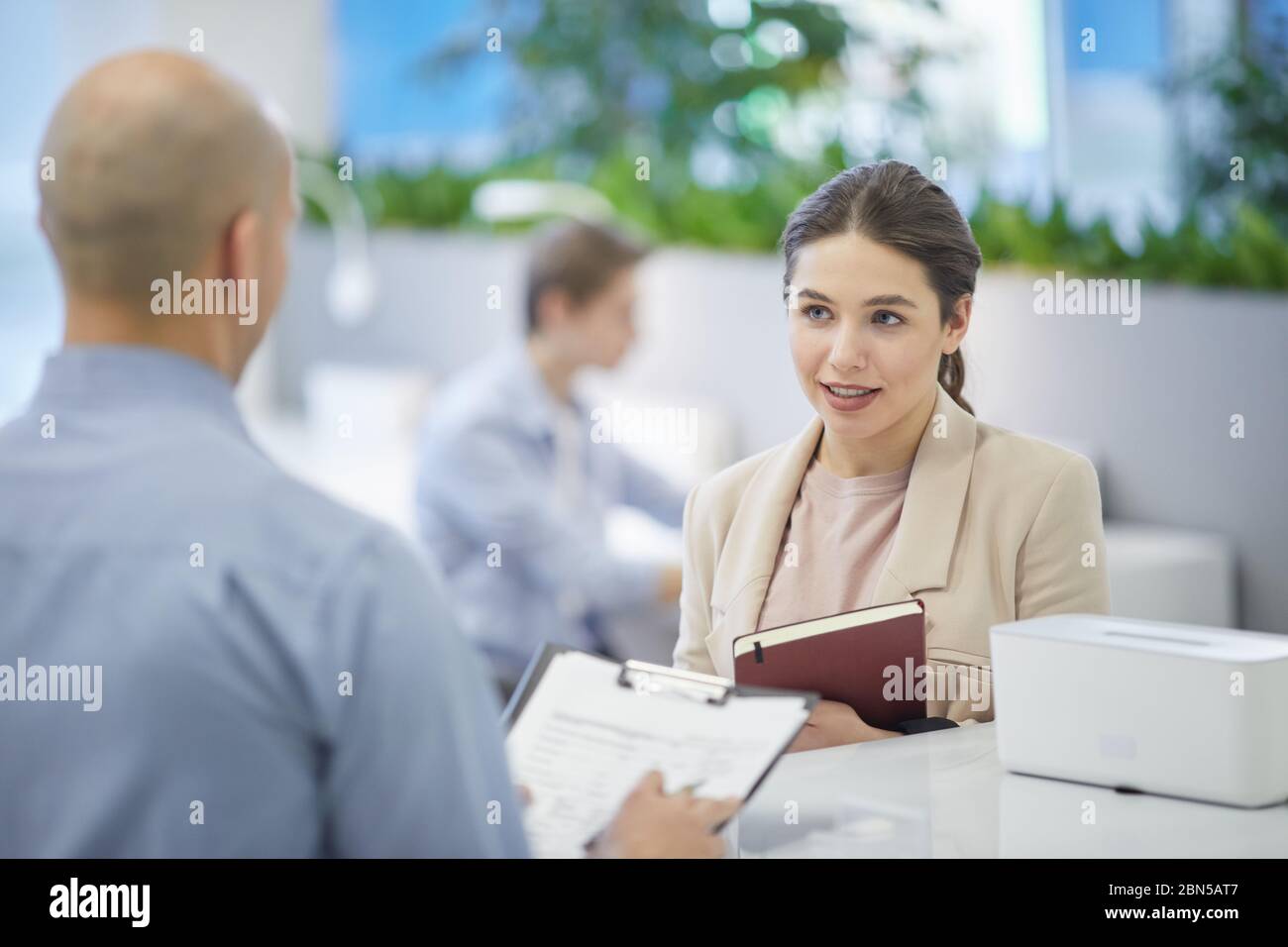 Portrait of smiling young businesswoman talking to boss or manager ...