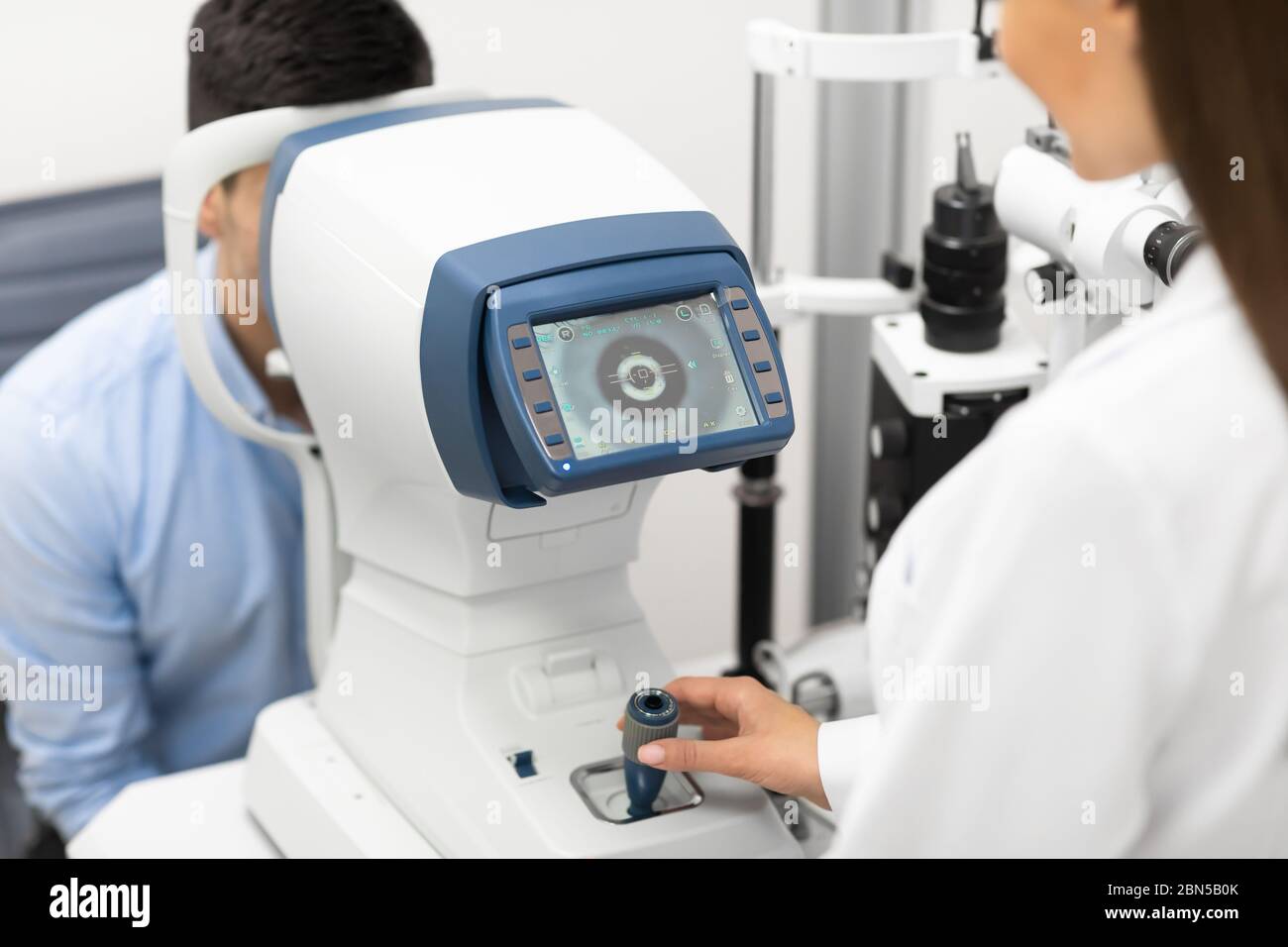Optometrist checking patients vision at modern clinic Stock Photo - Alamy