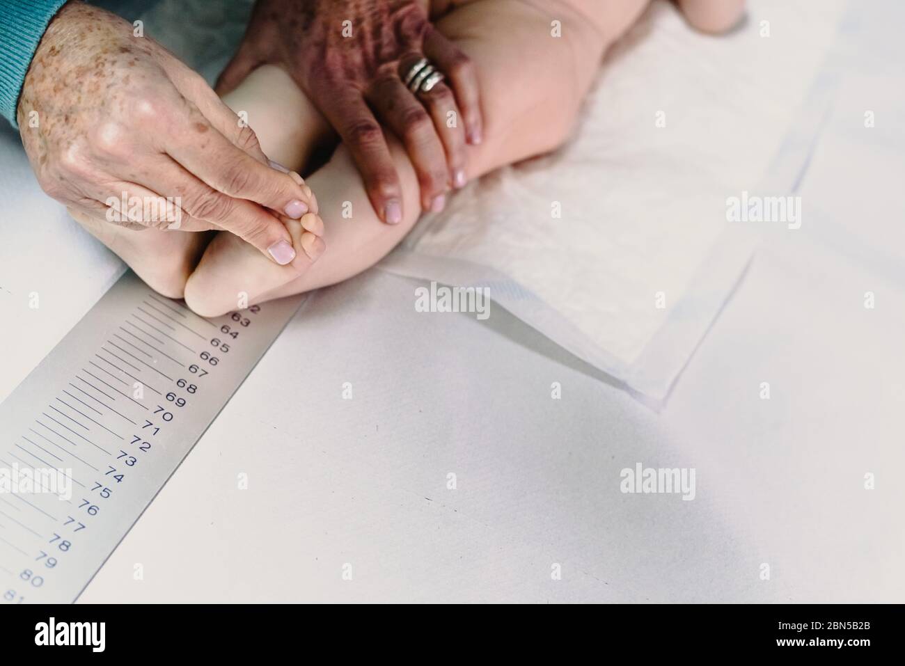 newly born in the clinic of the pediatrician measuring a height and ...