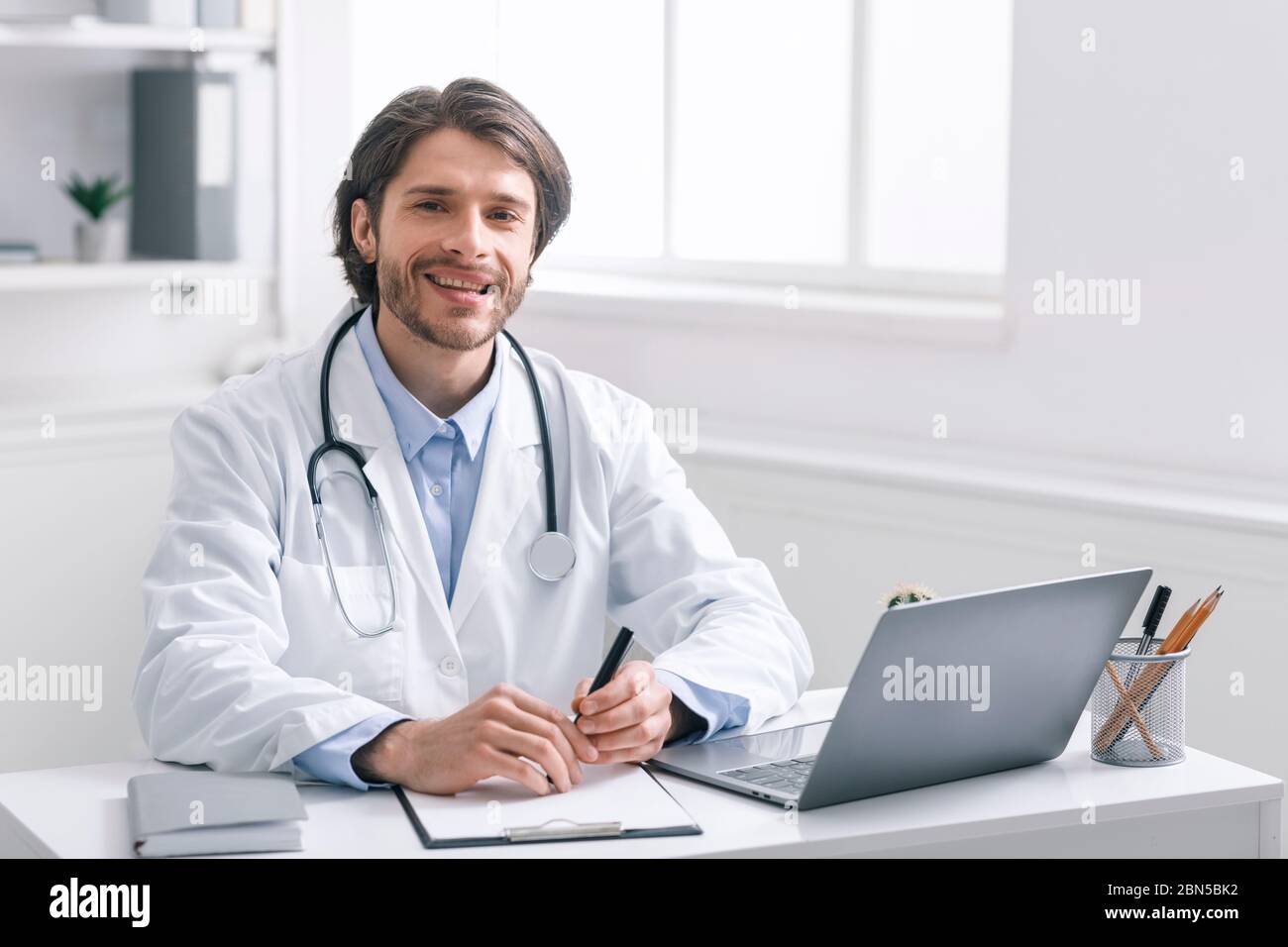 Medical doctor sitting at workplace in office Stock Photo - Alamy
